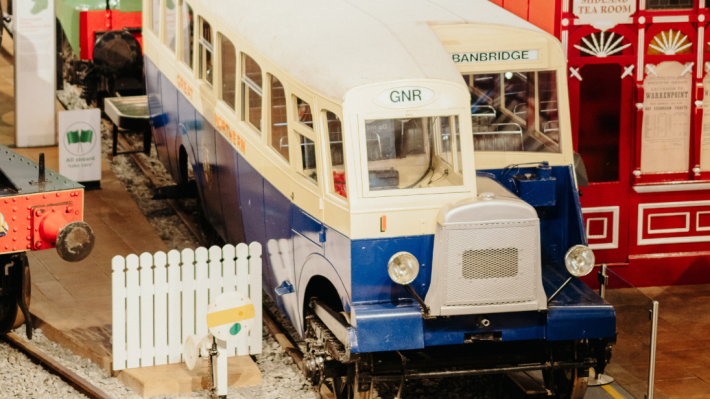 A blue and white bus inside a museum.