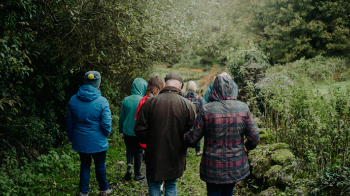 A group of people walking through a forest in the rain